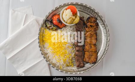 Grilled kebabs with vegetables and rice served on a plate Stock Photo ...