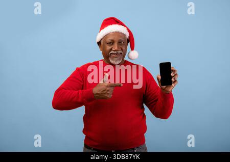 A man in a Santa hat stands by a camera tripod Stock Photo - Alamy