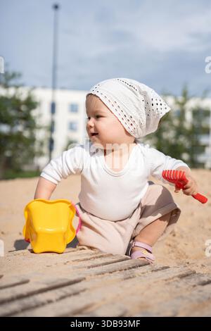 Adorable toddler playing with toys sitting on floor at kindergarten ...