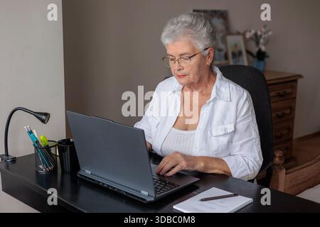 Senior woman doing online banking, paying domestic utility bills at ...