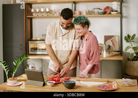 Young man and woman cooking food in kitchen together, happy couple ...