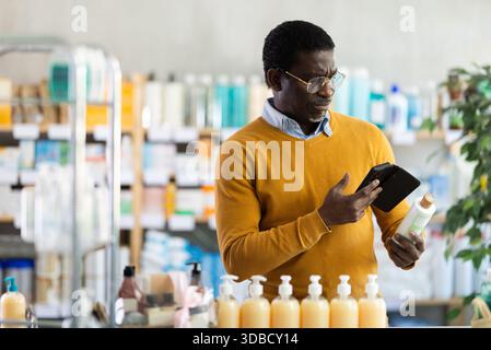 Man in glasses scans code on package of pills to check expiration date ...
