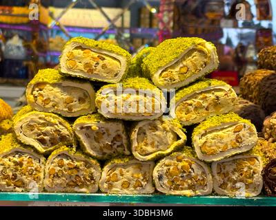 Pistachio filled nougat rolls coated in green crumbs stacked in a ...