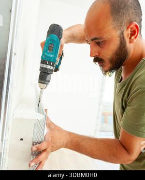 Worker using screwdriver in construction site, fuse box Stock Photo - Alamy