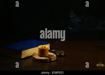 Incense sticks on a vintage book with fragrance bottles Stock Photo - Alamy