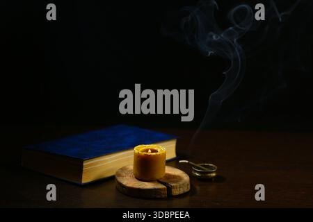 Incense sticks on a vintage book with fragrance bottles Stock Photo - Alamy