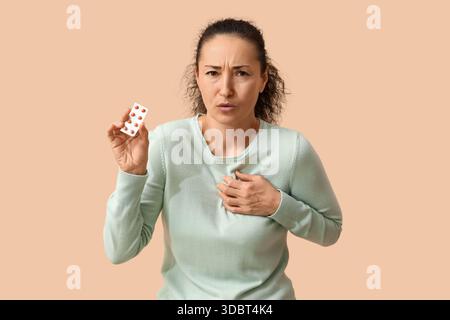 Mature woman with pills having heart attack on white background Stock ...