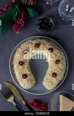 Festive salad in shape of horseshoe with chicken, eggs, cheese and ...