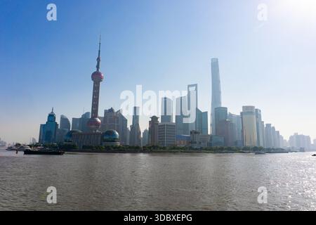 Oriental Pearl Tower against a clear blue sky with scattered clouds ...