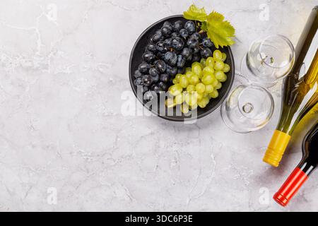 Wine bottles and grapes on stone table. Top view flat lay Stock Photo ...