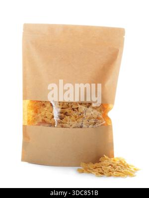 Stand-up pouch with raw pasta on wooden table against tiled background ...