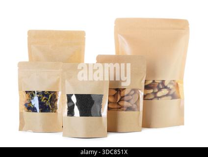Stand-up pouches with different products on wooden table against white ...