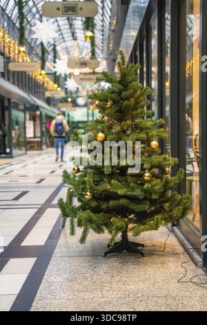 Modern glass Christmas tree with lights on dark wood table with wall ...