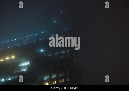 Illuminated skyscraper windows at night reveal city life through a grid ...