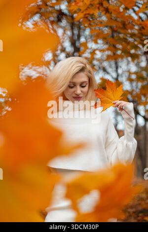 Women hand, yellow sweater and white mug. With a hot drink, marshmallow ...