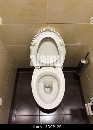 Modern white ceramic toilet with raised seat in a clean and minimal ...