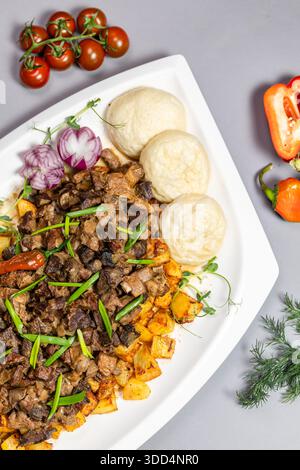 Close-up of Kuirdak with potatoes and bread rolls on set table Stock ...