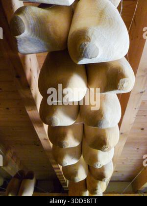 Unfinished wooden clogs hanging from the ceiling in a clogs factory ...