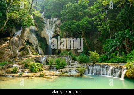 Tiered waterfalls flowing through layered rock canyon surrounded by ...