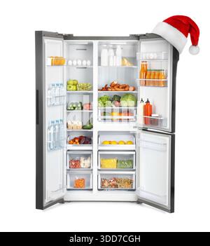 A bottle of milk with a santa claus hat and an alarm clock on the ...