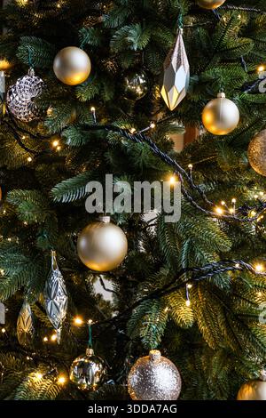 A tree decorated with festive garlands with luminous bulbs against the ...