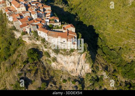 Cliffside village with rustic buildings set against a rocky desert ...