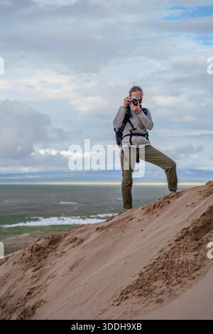 Traveler photographing scenic view in forest. One caucasian woman ...
