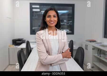 Portrait of young attractive company executive sitting at table with ...