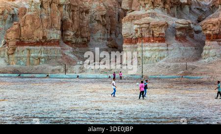 Boys playing football beneath Al Qarah Mountain, Al Ahsa Oasis, Hofuf ...