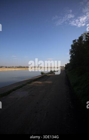 Dirt trail by the bank of a diversionary channel full of poppies ...