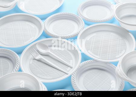 Different plates with bowls and spoon on blue background Stock Photo ...