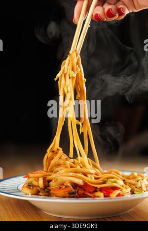Lifting Noodles with Chopsticks from a Bowl of Chinese Braised Beef ...