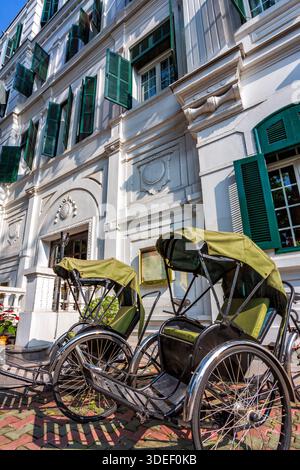 A bicycle rickshaw parked outside an old crumbling building in Lucknow ...