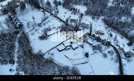 A footage of mountains covered with trees with cloudy sky and a road on ...