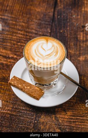 Coffee with latte art served on a tray beside a succulent plant and ...