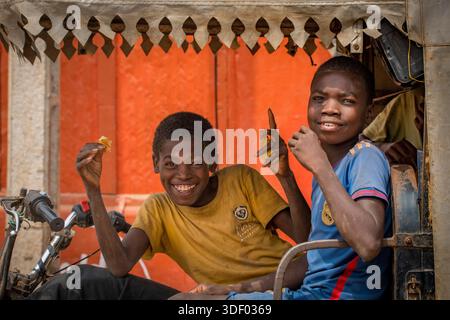 A spontaneous portrait of two Malagasy boys on the front of a motorised ...