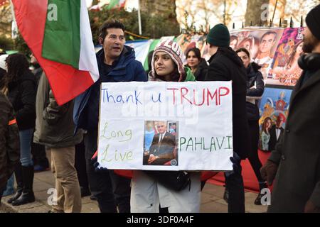 A pro-government Iranian protester holds up an anti-British placard in ...