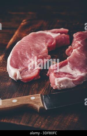 Two pork loin steaks with knife on rustic cutting board Stock Photo - Alamy