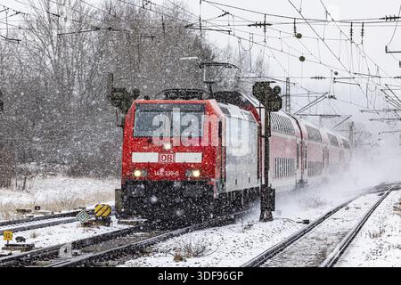 RegionalExpress RE on the road through a winter landscape in snowfall ...