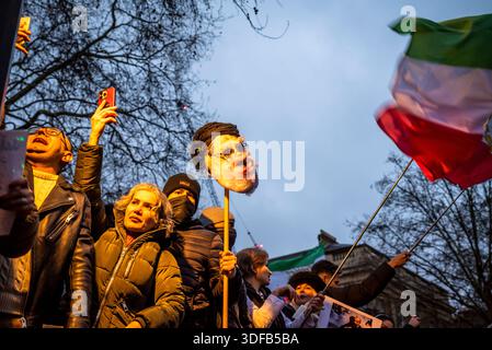 People carry Iranian flags and pro-government placards during a funeral ...