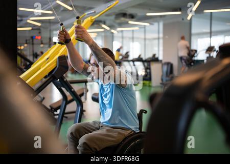 Concentrated disabled man in wheelchair working on spinal injury ...