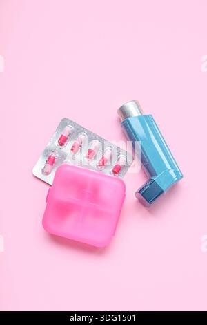 Asthma inhaler and pills on pink background, flat lay. Space for text ...