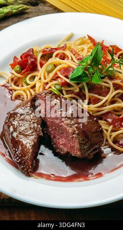 Pasta with a piece of grilled meat and salad Stock Photo - Alamy