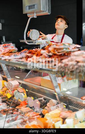 Male shop seller using scales for meat in butcher shop Stock Photo - Alamy