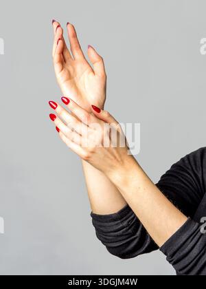 A human hand with manicured nails is touching a pile of translucent ...