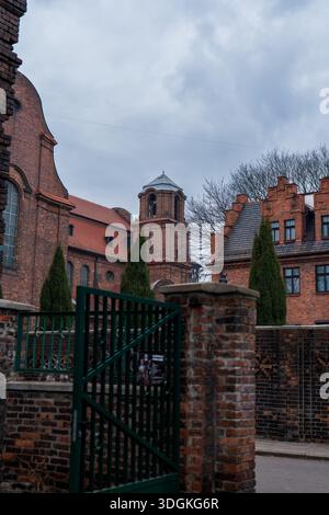 Spring view of red brick gothic church with twin spires framed by fresh ...