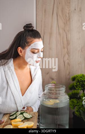 Young woman drinking cucumber water on blue background Stock Photo - Alamy