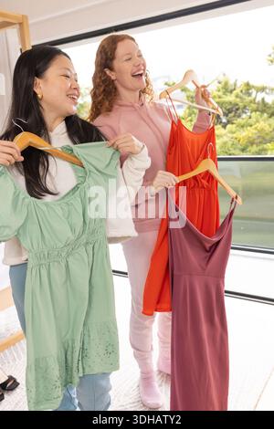 Wooden rack with hangers near pink wall Stock Photo - Alamy