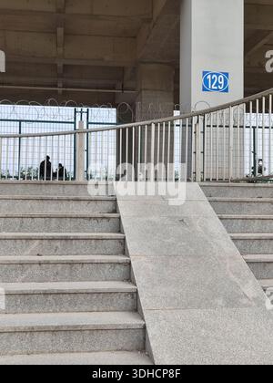 Outdoor stairs with ramp, metal railing and tactile tiles. Public ...