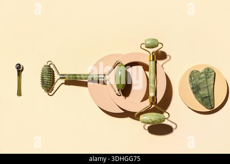 Facial massage tools and plaster stands on beige background, closeup ...